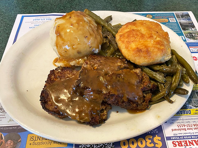 Meatloaf that would make your grandmother both jealous and proud, swimming in gravy alongside green beans and a biscuit standing guard.