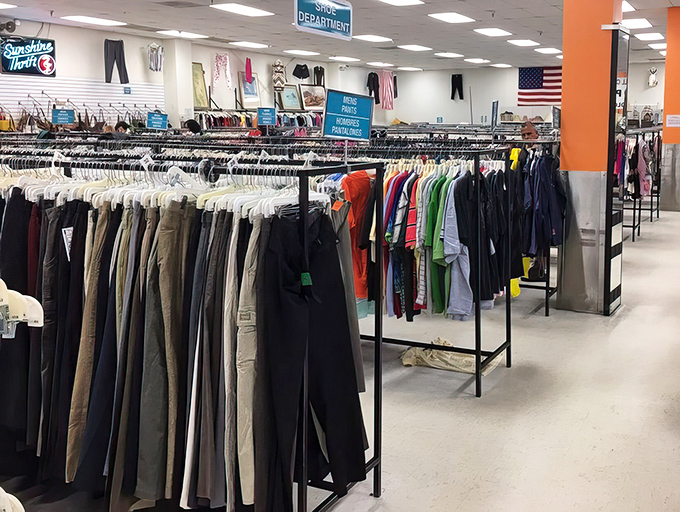 Men's clothing hangs in organized rows where professional wardrobes and casual comfort find their perfect balance.