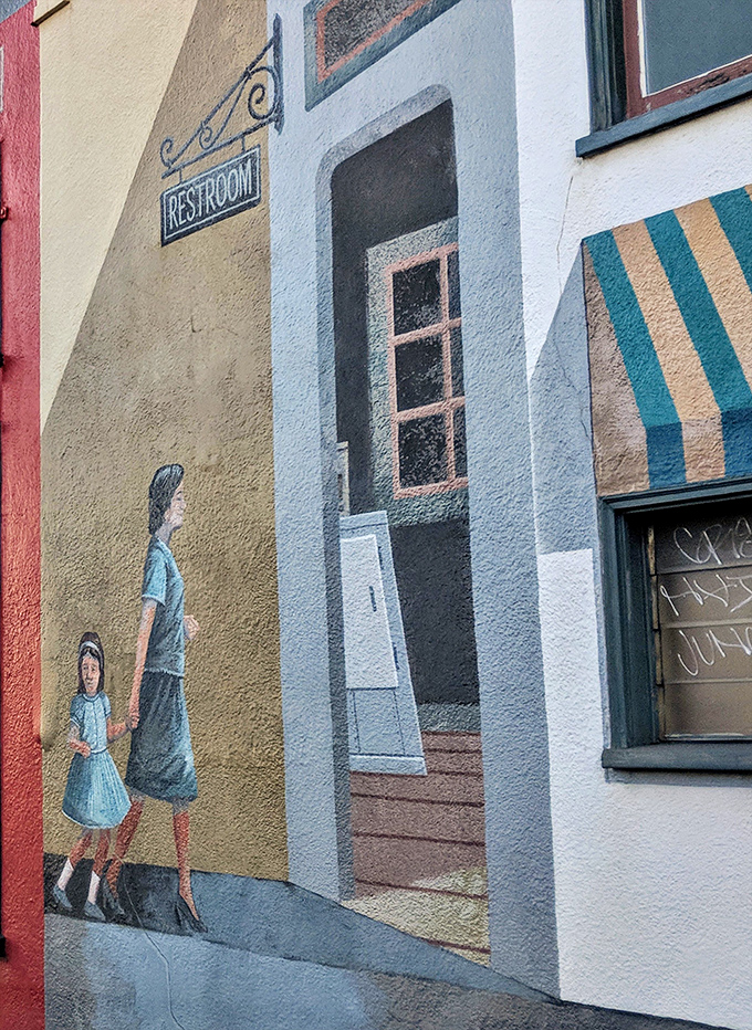 Even the restroom gets the artistic treatment with this charming trompe l'oeil mural adding unexpected whimsy to necessary functions.