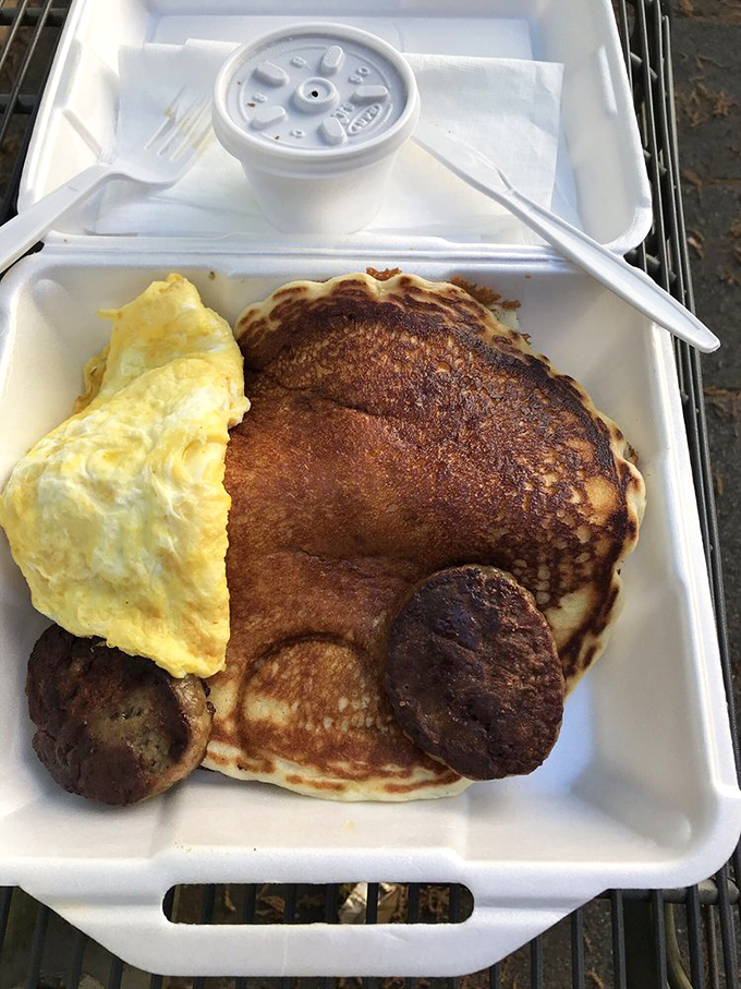 Breakfast doesn't get more honest than this – a golden pancake with eggs and sausage that says "good morning" better than coffee ever could.