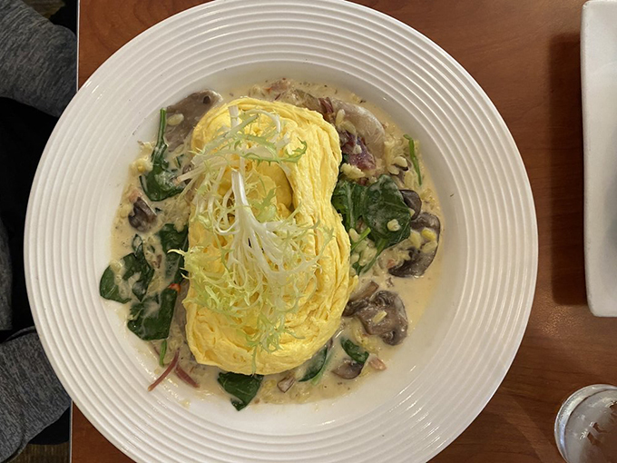 An omelet so perfectly executed it deserves its own museum exhibit. The creamy sauce cradles the fluffy eggs like they're precious artifacts of deliciousness.