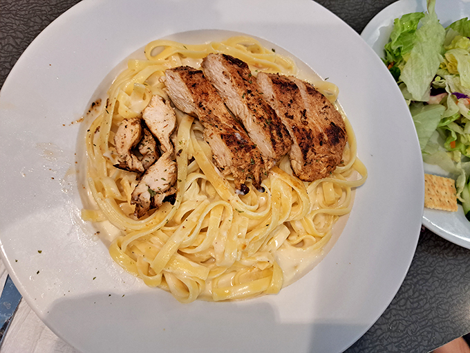 Fettuccine Alfredo with grilled chicken&mdash;where comfort food gets dressed up for a night out but still remembers its humble, delicious roots.