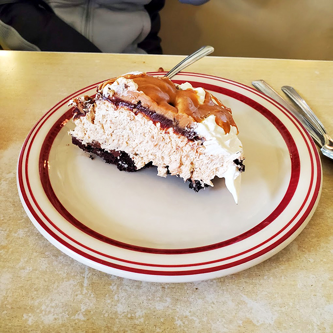 This slice of peanut butter pie isn't just dessert—it's therapy on a plate, with layers of creamy decadence that make you wonder why anyone bothers with kale.