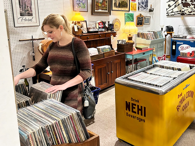 Vinyl revival headquarters where music lovers flip through history one album at a time. That yellow NEHI cooler is the perfect retro bonus.