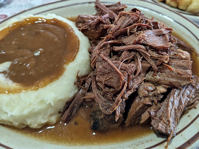 Pot roast so tender it practically surrenders at the sight of your fork, beside mashed potatoes that could end wars.