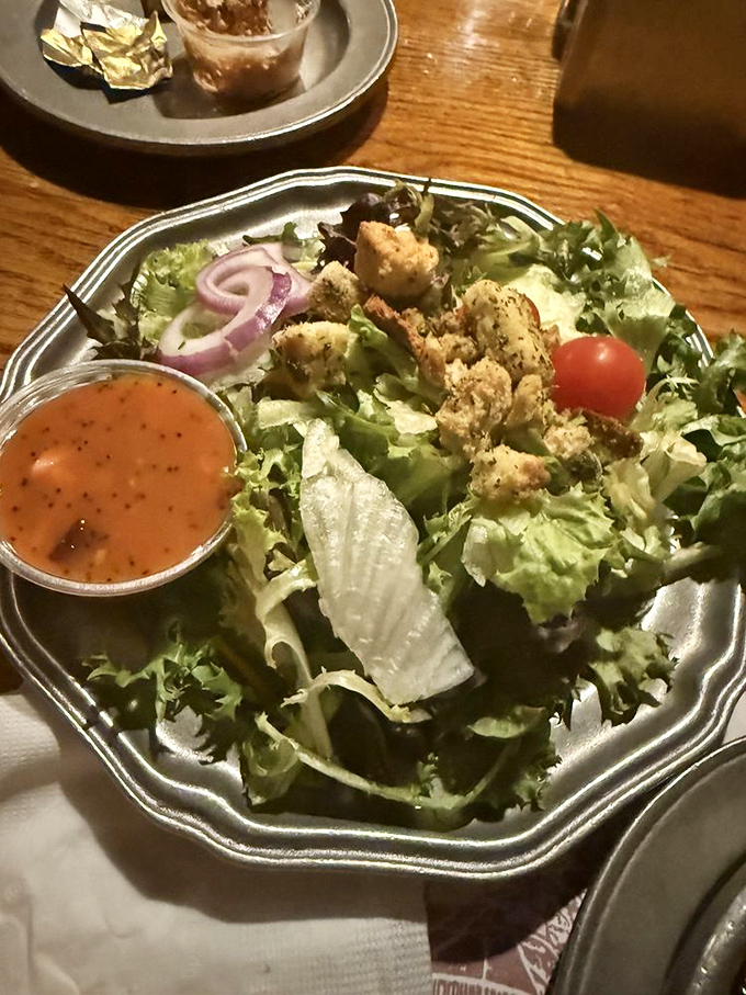 A garden party in metal-bowl form, where fresh greens host croutons that crunch like autumn leaves underfoot.