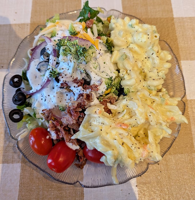 A glass plate divided like the perfect marriage&mdash;garden-fresh salad on one side, creamy macaroni on the other, proving opposites really do attract.