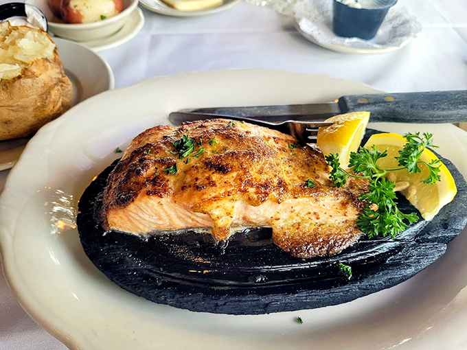 Perfectly seared salmon on a sizzling platter&mdash;crispy outside, tender inside, with a hint of lemon to brighten every bite.