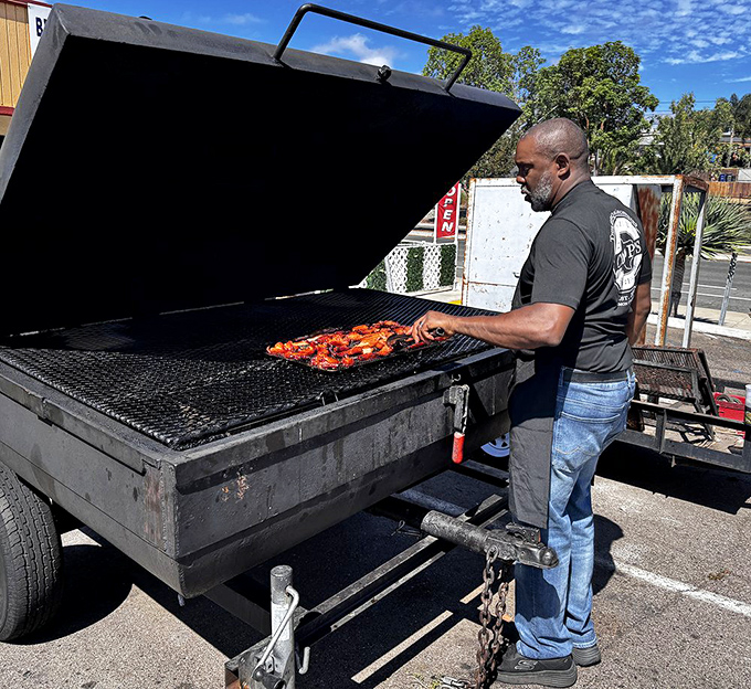 The pitmaster at work, tending to meat like an artist to canvas. This is where the magic happens, one careful flip at a time.