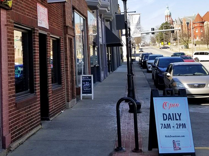 Downtown Huntington's sidewalk view with Nick's Kitchen hours proudly displayed. Some treasures require planning to capture—7am to 2pm daily.