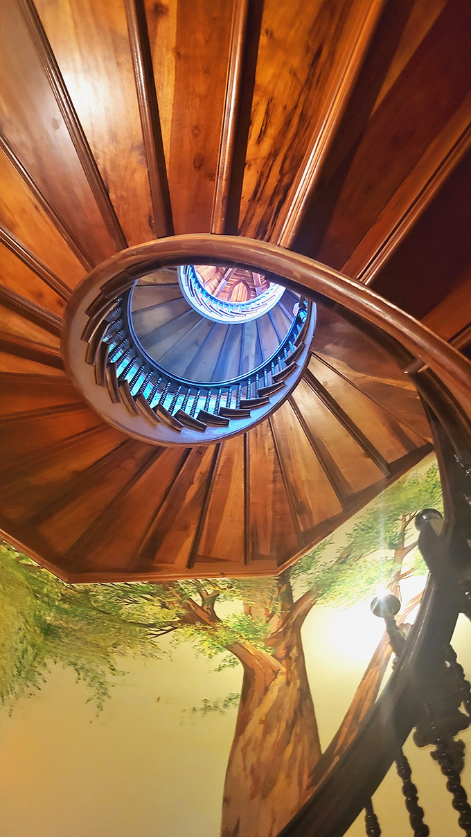 Looking up this spiral staircase reveals the castle's artistic soul&mdash;rich wood, stained glass, and murals combine in a dizzying display of craftsmanship.