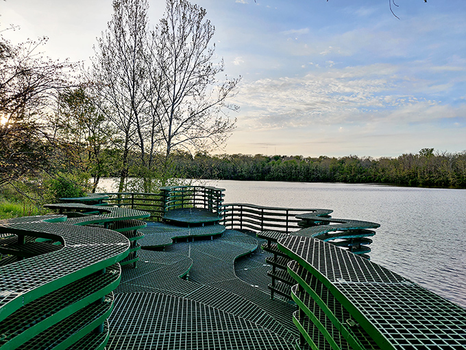 Nature's balcony reimagined in metal. This lakeside platform offers visitors a floating perspective over water, like standing on a geometric lily pad.