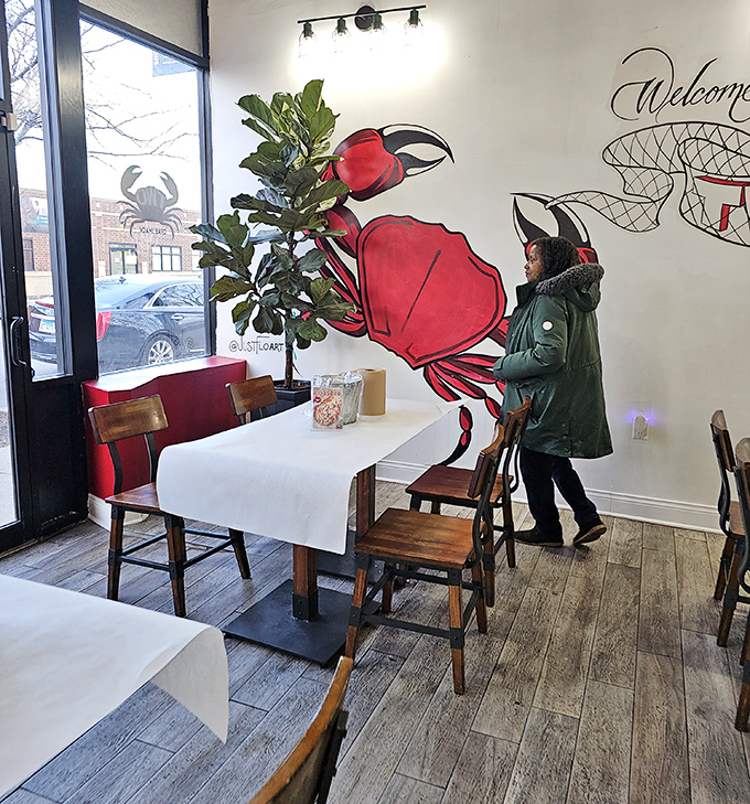 The bright crab mural watches over diners like a spicy guardian angel, reminding you what you came for.
