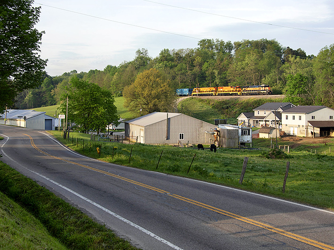 A quiet rural road with a train passing through - where the railroad and horse-drawn buggies still peacefully coexist.