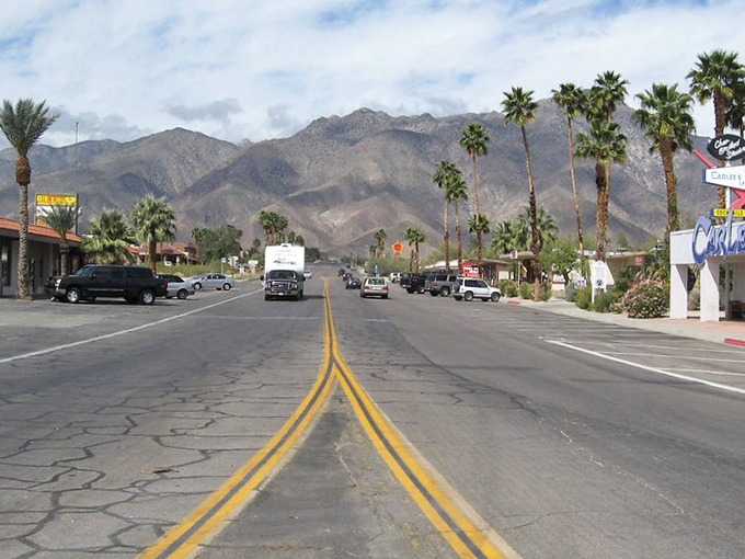 Desert town simplicity shines brightest when palm trees frame mountain views that stretch endlessly toward the horizon.