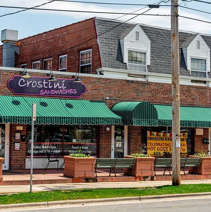 Green awnings and brick charm create the perfect backdrop for neighborhood sandwich shop magic.