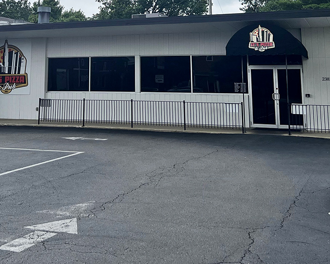 Dark windows and understated elegance suggest serious pizza business happening behind that modest entrance.