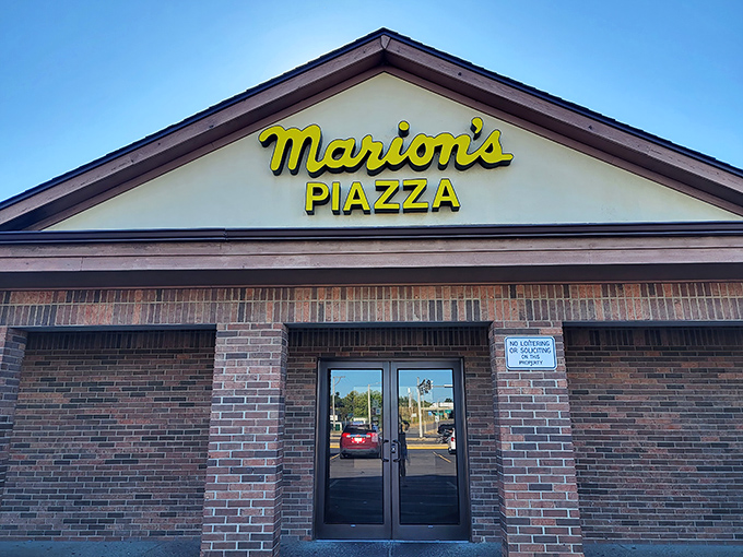 Yellow script lettering on brick screams classic American pizzeria from the golden age of comfort food.