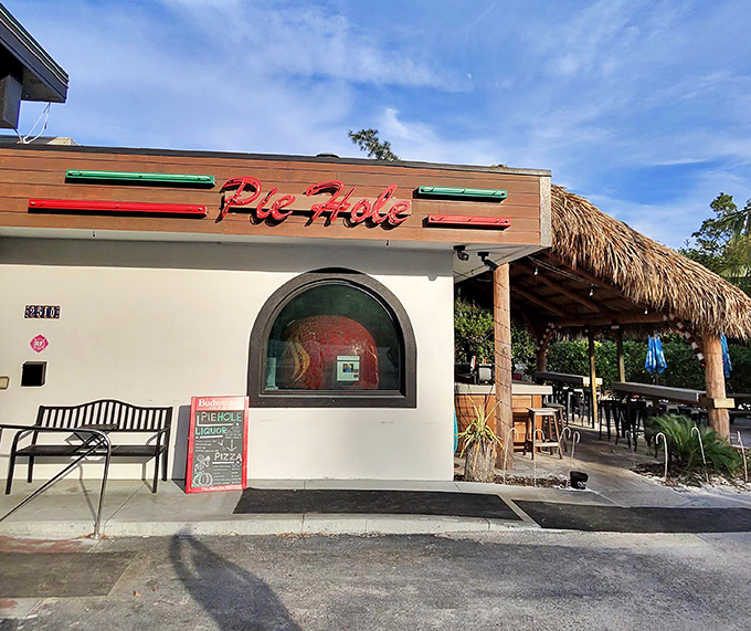 Pie Hole's rustic thatched roof and visible brick oven announce serious wood-fired pizza craftsmanship from the street.