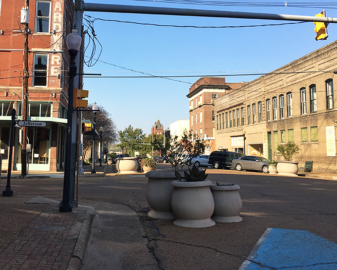 Yazoo City's concrete planters anchor this intersection like sturdy guardians of small-town charm and affordability.