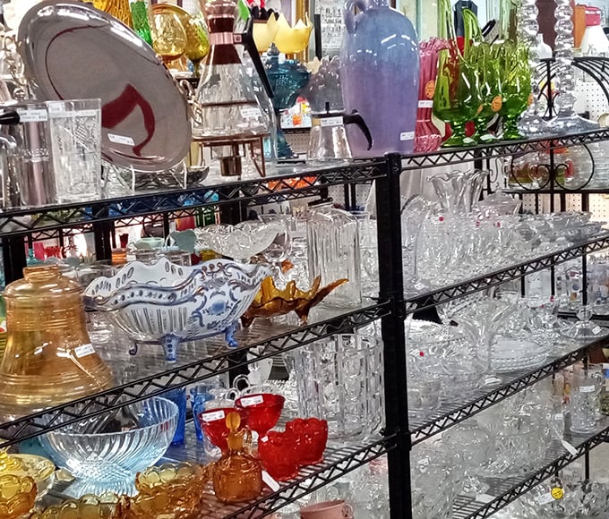 Colorful glassware catches the light beautifully, turning ordinary shelves into sparkling displays of vintage magic.