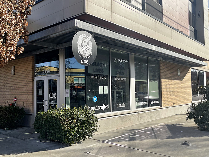 The minimalist design of Doe Donuts' exterior, with its striking deer logo, reflects the shop's contemporary approach to the classic donut. "Handcrafted donuts" promises quality inside.