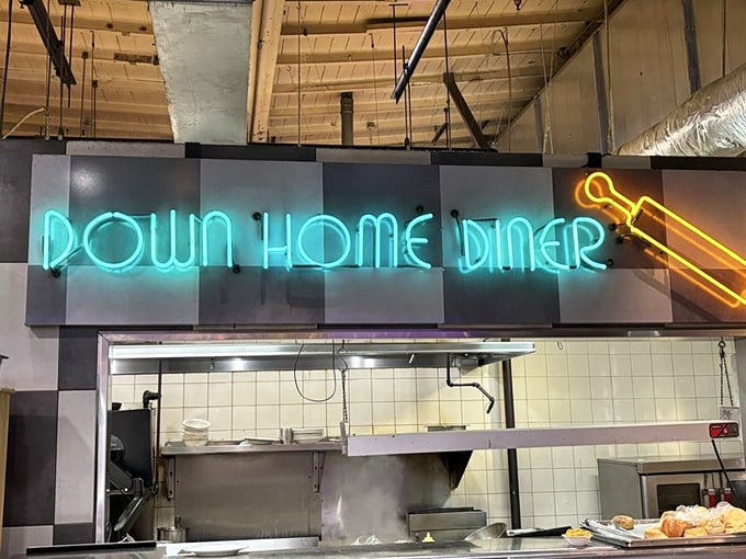 Behind that glowing sign is a kitchen that knows its way around a griddle. The open kitchen is dinner and a show.