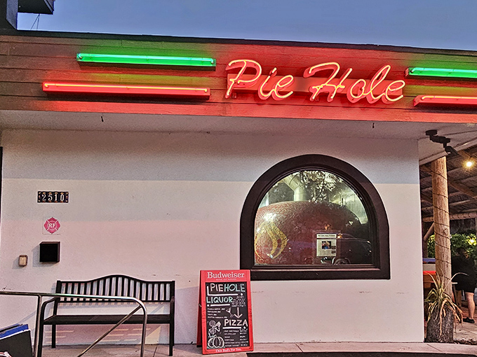 That glowing sign and arched window create the perfect pizza speakeasy vibe—like you've discovered a delicious secret.