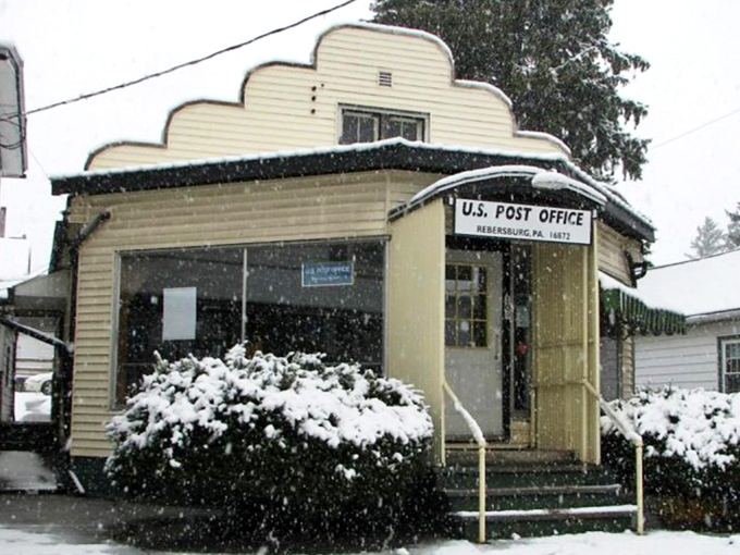 That adorable post office looks like a movie set, complete with snow-covered bushes framing the entrance perfectly.
