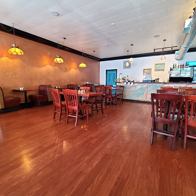 Warm wooden floors, rustic red chairs, and amber lighting create the perfect stage for breakfast drama to unfold&mdash;no reservations required, just an appetite.