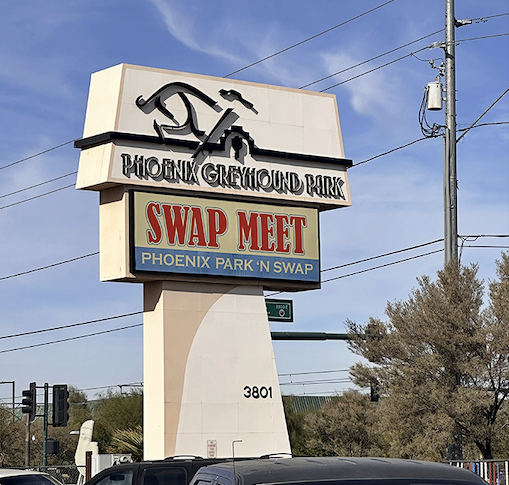 This classic roadside sign stands tall like a beacon for bargain hunters, promising treasures await inside.