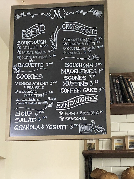 That chalkboard menu is like a treasure map where X marks the spot for kouign amann, danishes, and other buttery delights worth their weight in gold.