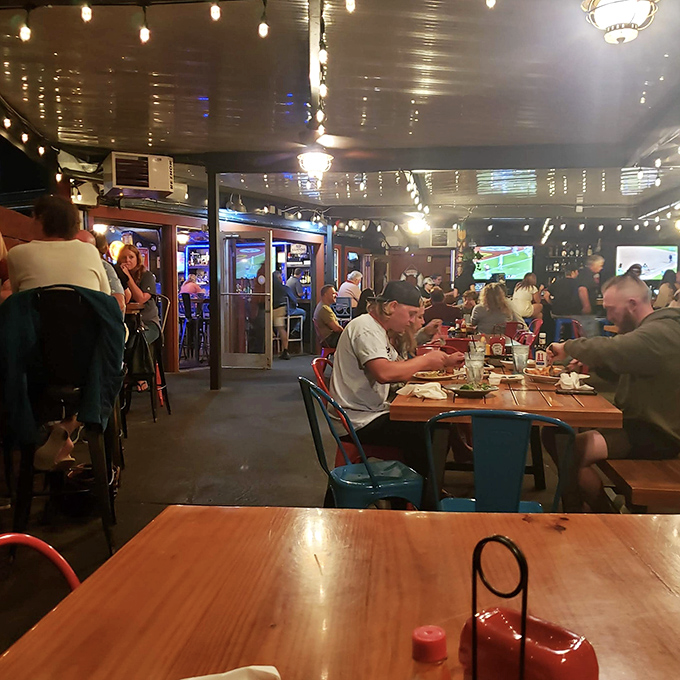 The bustling interior hums with conversation and clinking glasses, string lights casting a warm glow that makes everyone look like they're having the time of their lives.