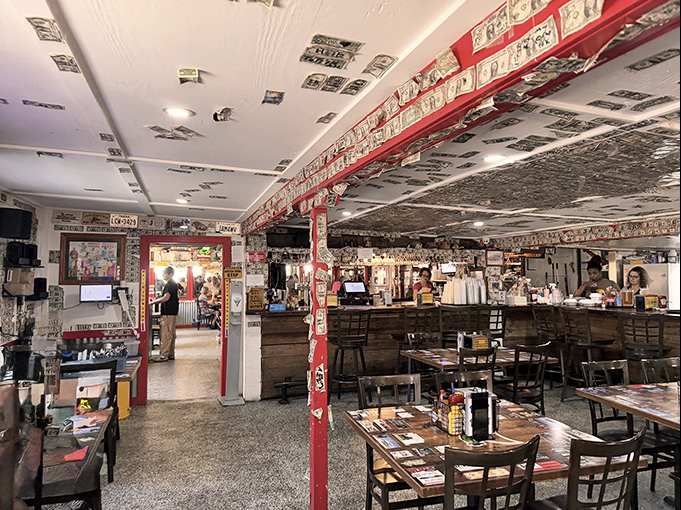 Dollar bills papering every surface tell stories of visitors past&mdash;a currency collage that's part decor, part guest book, all character.