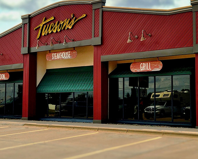 The bold red exterior of Tucson's Steakhouse stands like a beacon for hungry travelers, promising carnivorous delights within those Western-styled walls.