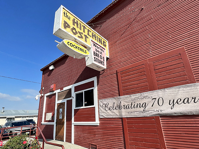 The iconic red exterior of the Hitching Post stands like a time capsule in Casmalia, promising carnivorous delights within its weathered walls.