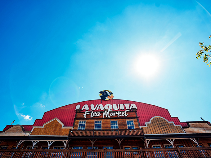 The iconic red barn facade of La Vaquita stands proudly against a brilliant Georgia sky, its cartoon cow mascot seemingly winking at visitors below.