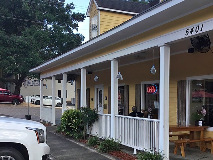 The welcoming front porch of Meat Boss beckons like a yellow beacon of barbecue bliss on Cottage Hill Road. Southern hospitality starts before you even reach the door.