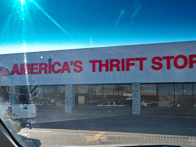The red signage version of America's Thrift Stores stands out against the bright blue sky, promising adventures in affordable shopping.