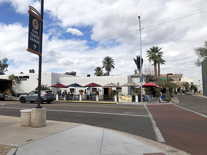 The white-walled charm of Los Olivos beckons from the corner, red umbrellas promising shade and satisfaction in equal measure.