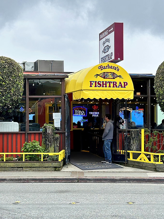 The iconic yellow awning of Barbara's Fishtrap stands out like a beacon of seafood salvation on Half Moon Bay's coastline, promising maritime delights within.