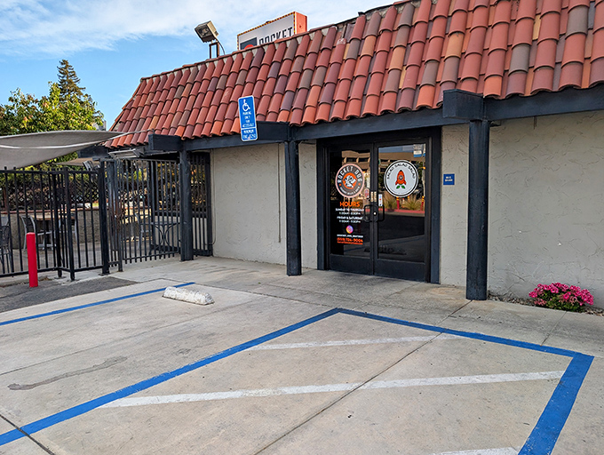 The unassuming exterior with its distinctive red-tiled roof might fool you, but inside awaits a temple to tubular meat excellence that will change your hot dog standards forever.