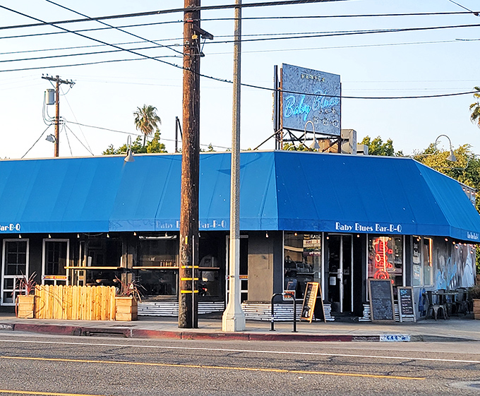 A California sunset frames Baby Blues BBQ's iconic blue awning &ndash; proof that sometimes paradise smells like smoke and tastes like heaven.