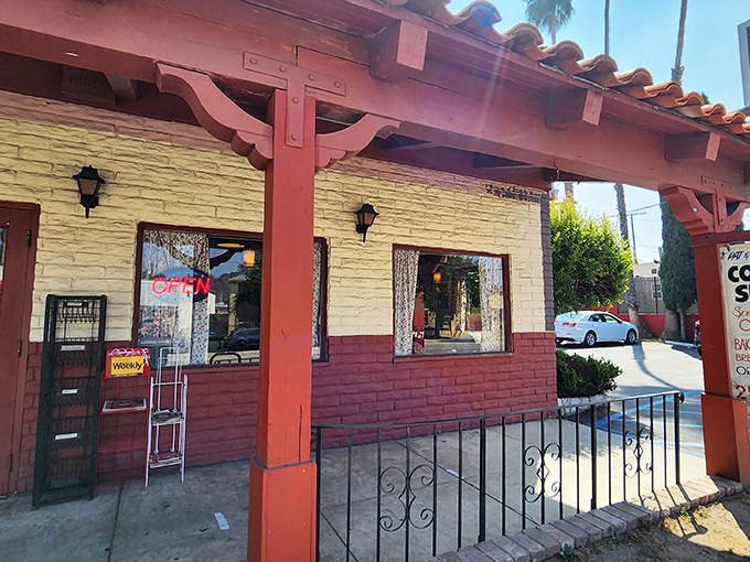 Red wooden beams frame the entrance like a portal to breakfast nirvana, where lace curtains hint at the homey experience waiting inside.