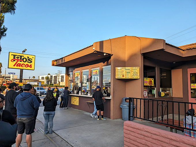 The iconic yellow sign beckons hungry pilgrims like a taco lighthouse. At Tito's, the line isn't a deterrent—it's part of the experience.