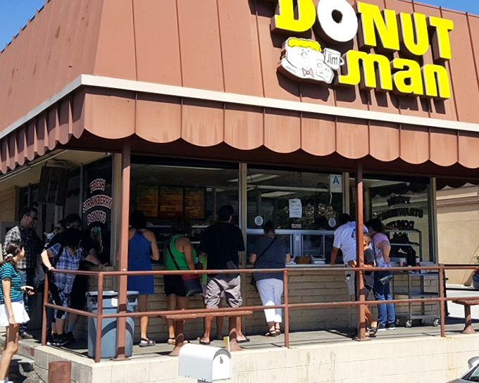 The iconic orange-brown awning of The Donut Man stands as a beacon of sweetness on Route 66, where pilgrims of pastry make their delicious hajj.