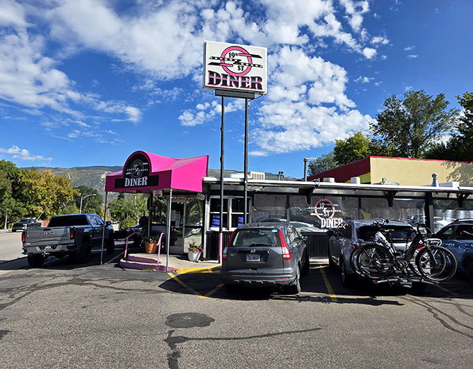 The pink awning of 19th St. Diner stands out like a beacon of breakfast hope against Colorado's mountain backdrop.