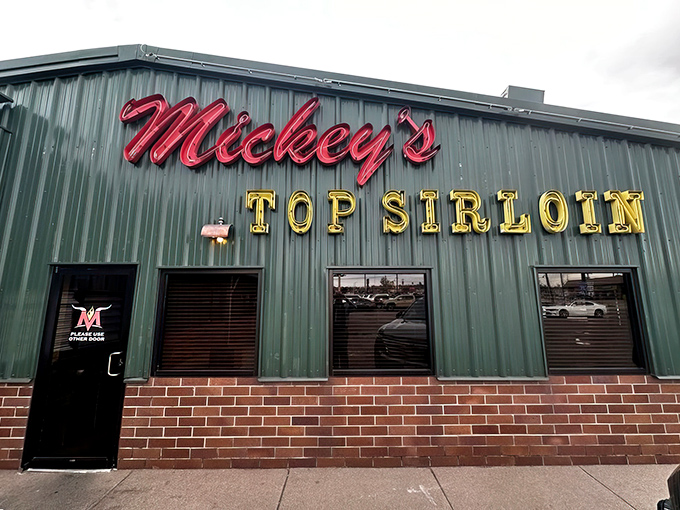 The iconic green exterior and glowing neon sign of Mickey's Top Sirloin stands as Denver's beacon for serious steak lovers.