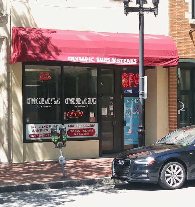 The iconic red awning of Olympic Subs & Steaks stands out like a beacon for sandwich lovers. No fancy frills, just the promise of Delaware's finest cheesesteaks inside.