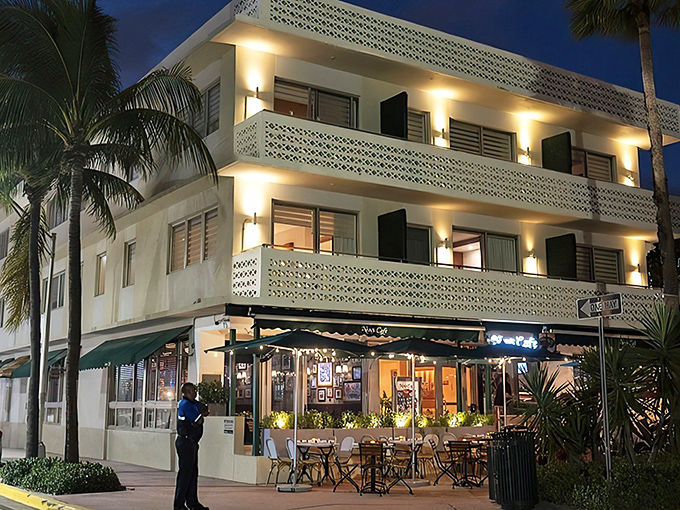 As night falls, News Cafe transforms into a glowing beacon of South Beach nightlife, its illuminated exterior inviting night owls and early birds alike.